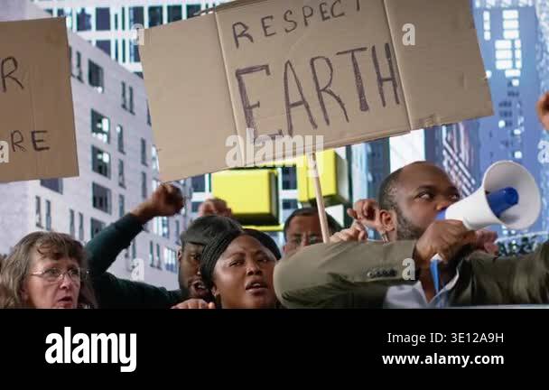 Diverse crowd of activists marching in a climate protest with banners ...