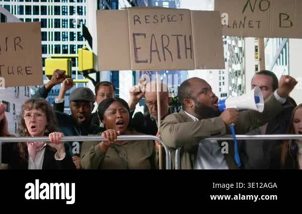 Diverse crowd of activists marching in a climate protest with banners ...