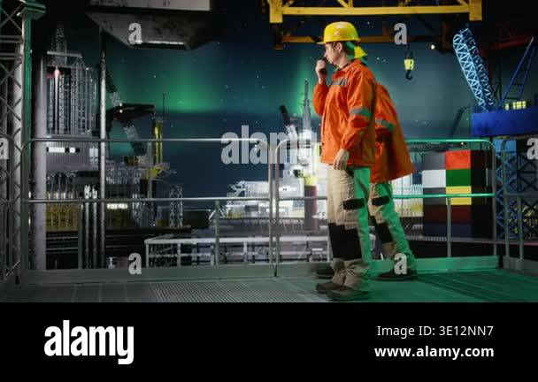 Environmental officers on oil rig platform communicating via radio ...