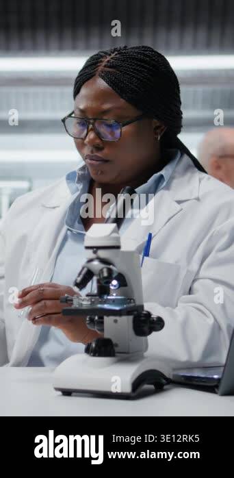 Vertical video Clinical laboratory technologist pipetting reactant into ...