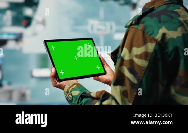 Military operator in war room oversees mission operations using green ...