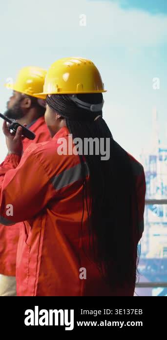 Vertical video Offshore platform specialist using portable radio device ...