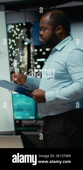 Vertical Video Male advisor drawing candlestick charts on a white board ...