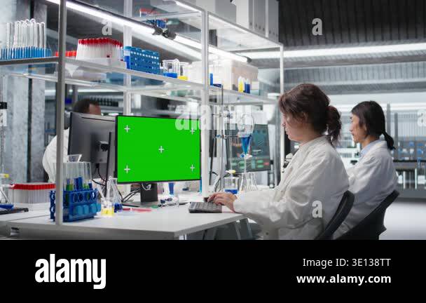 Scientist working on green screen PC in lab, studying genomics ...