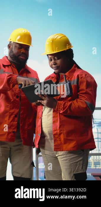 Vertical video Happy offshore platform engineering team monitoring ...