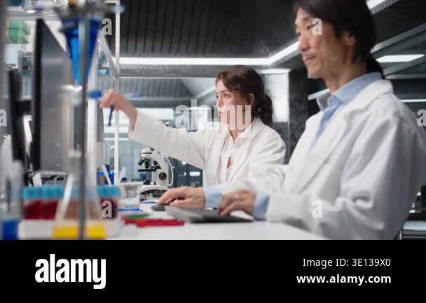 Chemical engineer using laboratory glassware with blue indicator ...