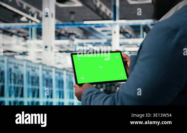 Green screen tablet used by data center worker to manage enterprise ...