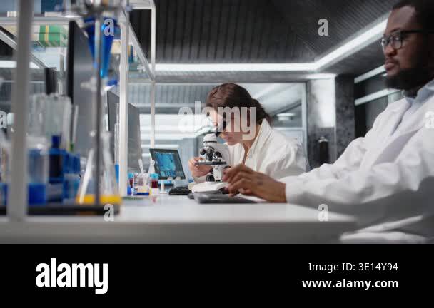 Cytotechnologist adjusts microscope, zooms on cellular structures in ...