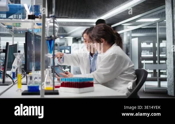 Laboratory manager and trainee using tablet app to process DNA patient ...