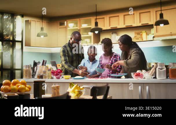 Happy cheerful parents teaching kids how to cook a homemade pizza ...