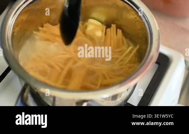 Spaghetti submerged in boiling water inside cooking pot. Spaghetti ...
