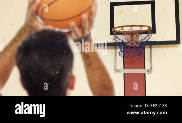 Male shooter raising ball and releasing to score at hoop, yellow ...