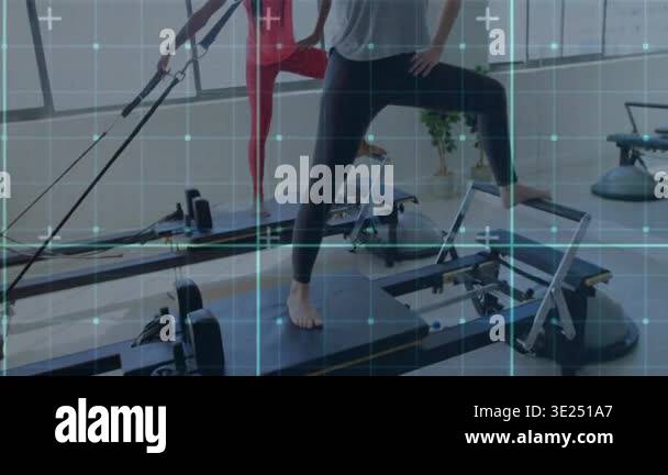 Two women stepping onto reformers and holding cable lunges for Pilates ...