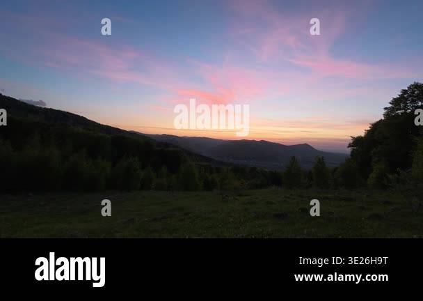 Majestic colorful cloudy sky over beautiful tops of hills in evening ...