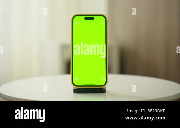 Front view of a modern smartphone with bright green chroma key display ...