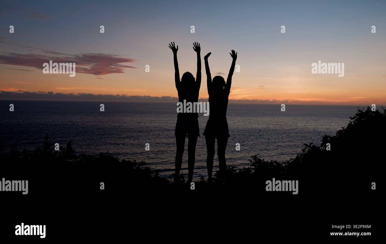 Two girls at sunset raised arms and hugging Stock Video Footage - Alamy