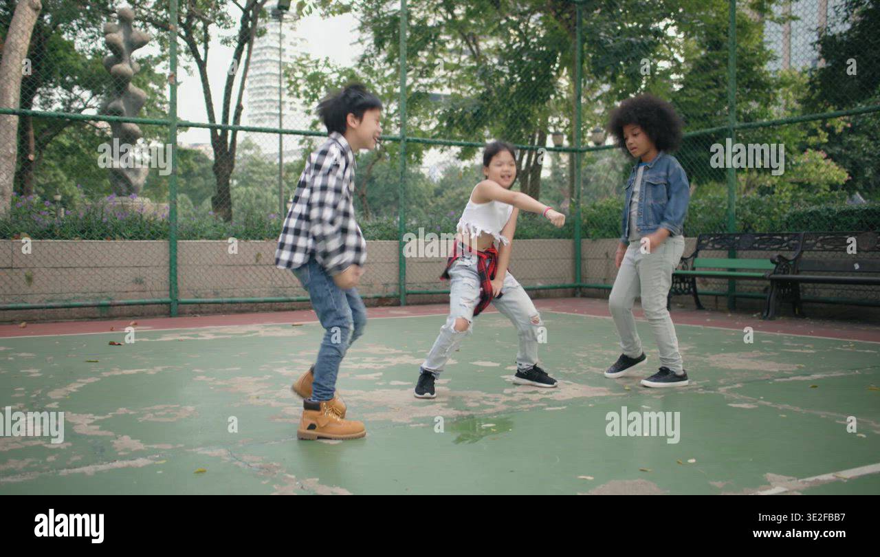 Group of three kids dancing together outside in a park Stock Video ...