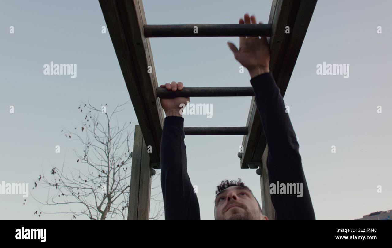 Athletic man climbing monkey bar working out on field Stock Video ...