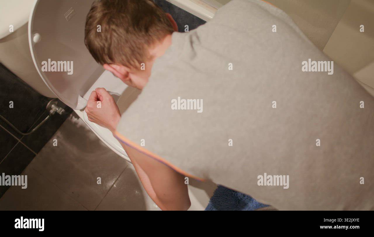 Drunk man puking into toilet Stock Video Footage - Alamy
