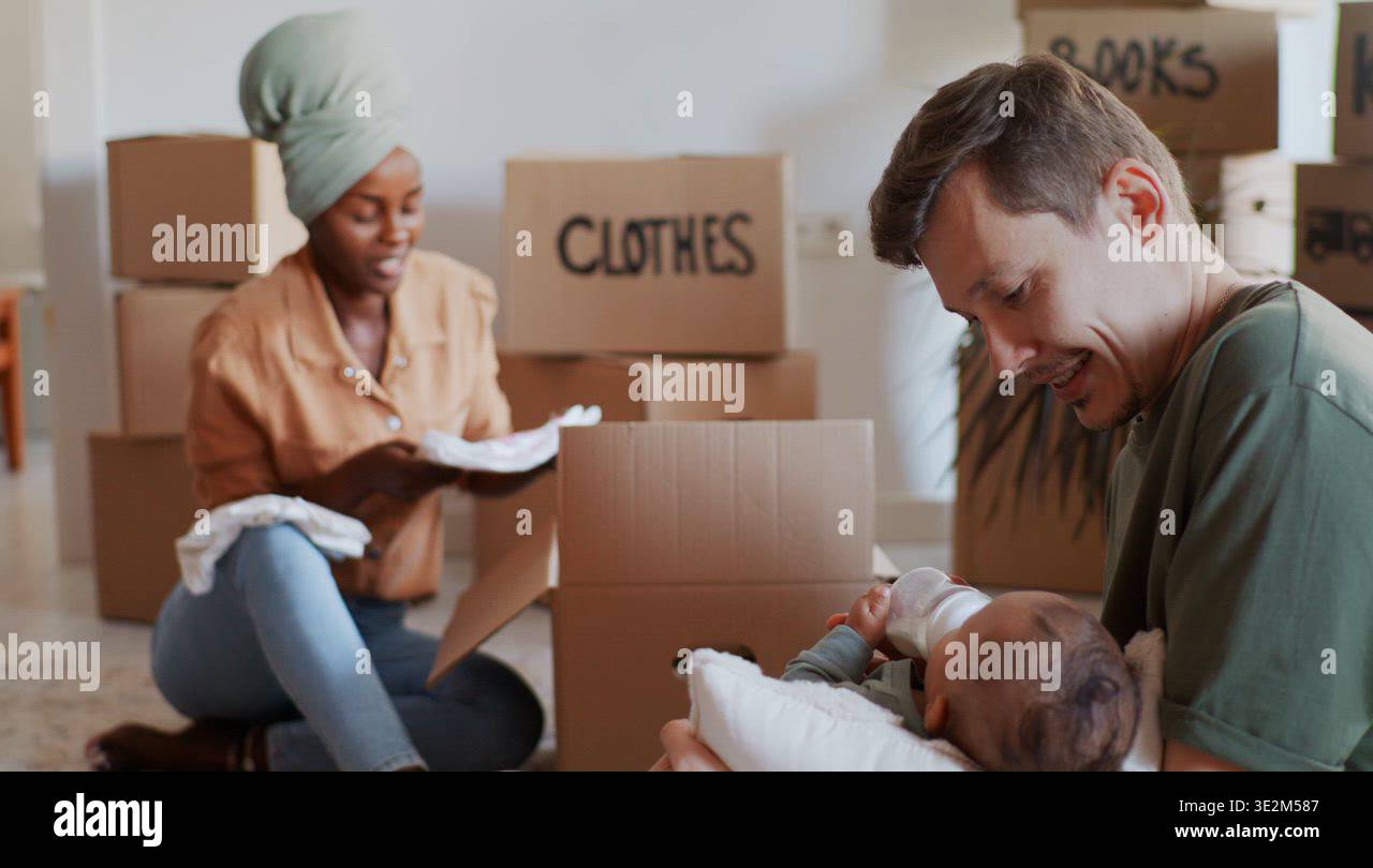 Father feeding baby near mother unpacking carton boxes Stock Video ...