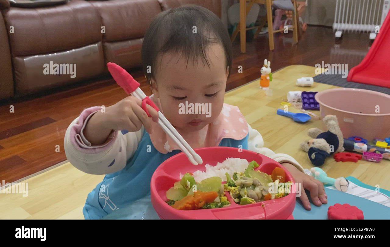 Asian babies use chopsticks to eat on her own Stock Video Footage - Alamy