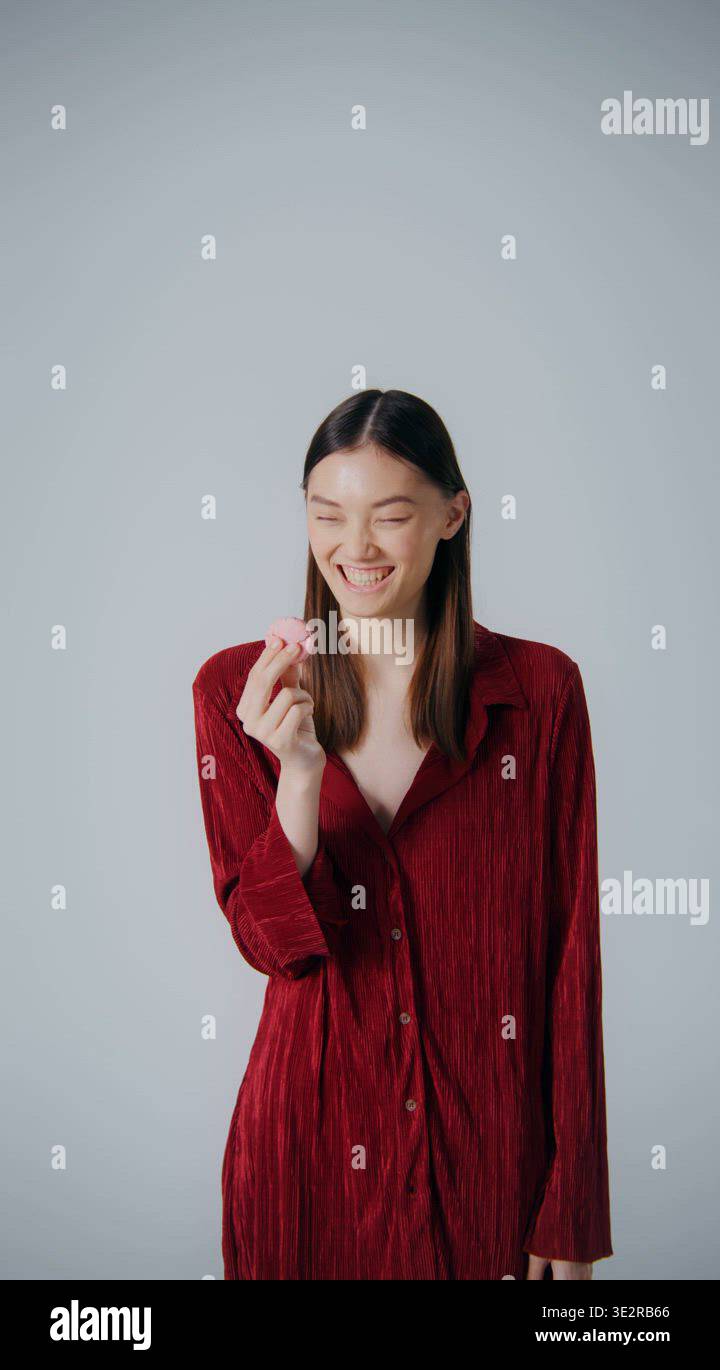 A woman eats macaroon in the studio Stock Video Footage - Alamy