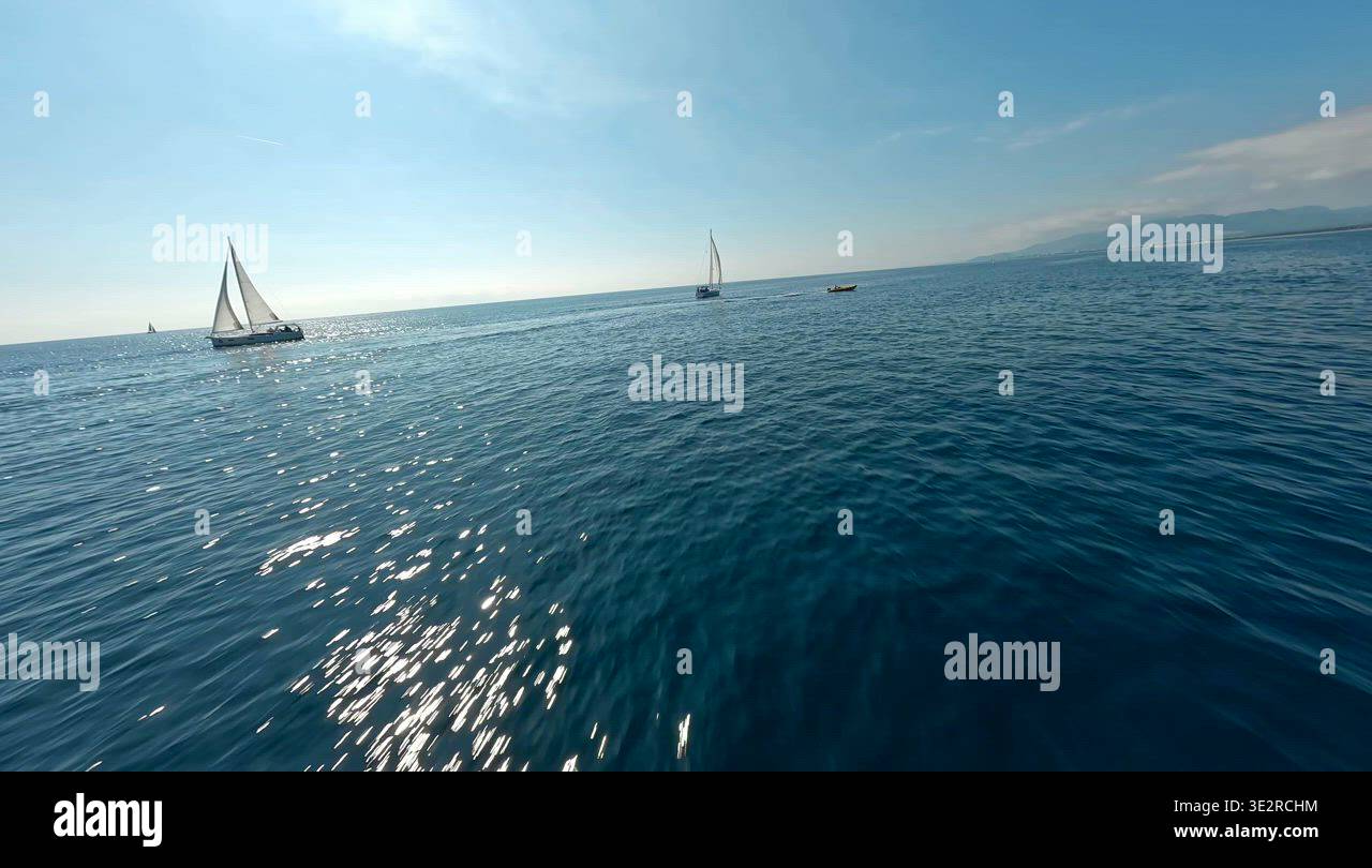 Fpv drone shot flying close to white sails Yachts competing Regata ...