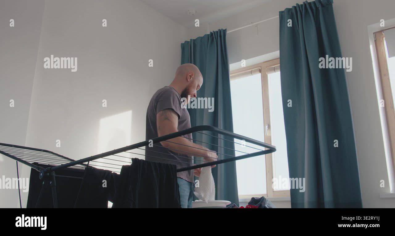 Bald Man Hanging Laundry on Drying Rack Stock Video Footage - Alamy