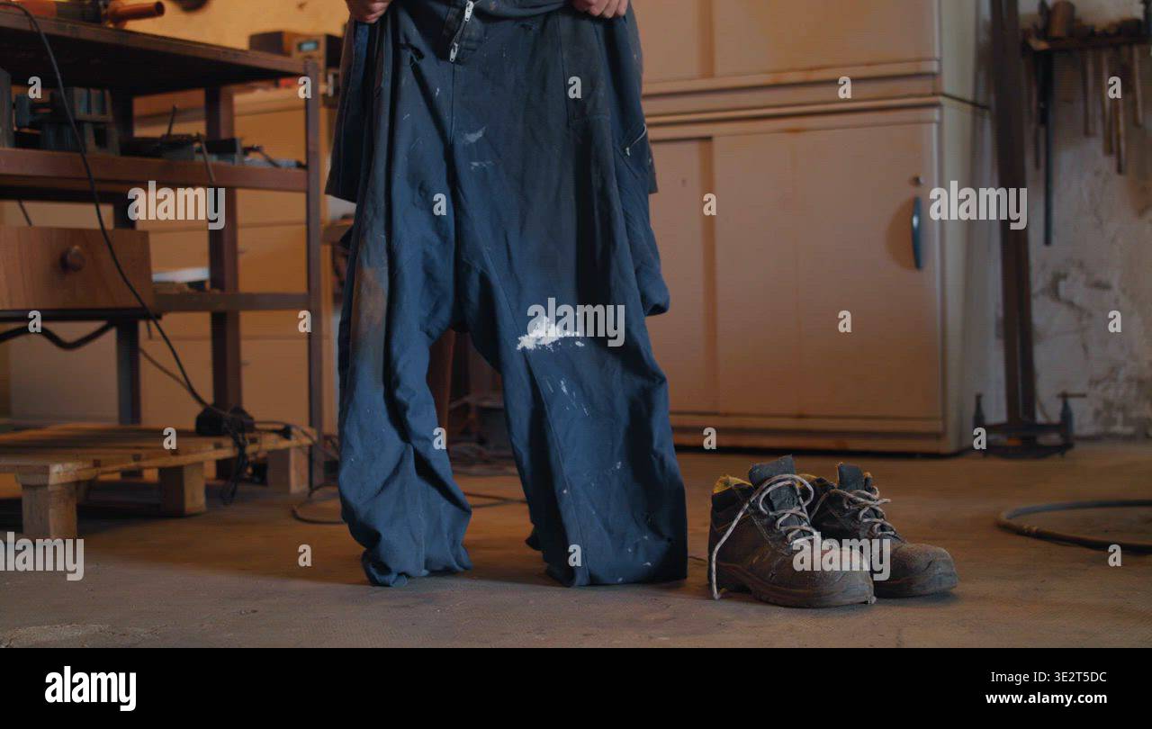 Anonymous worker putting on dirty overall Stock Video Footage - Alamy