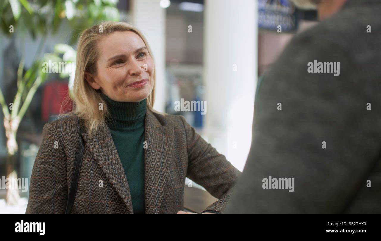 Smiling adult woman talking with cropped man at mall on weekend Stock ...