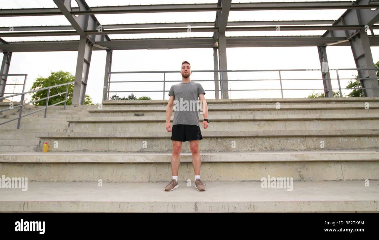 Athletic man doing cardio jumping on stairs during outdoor workout ...