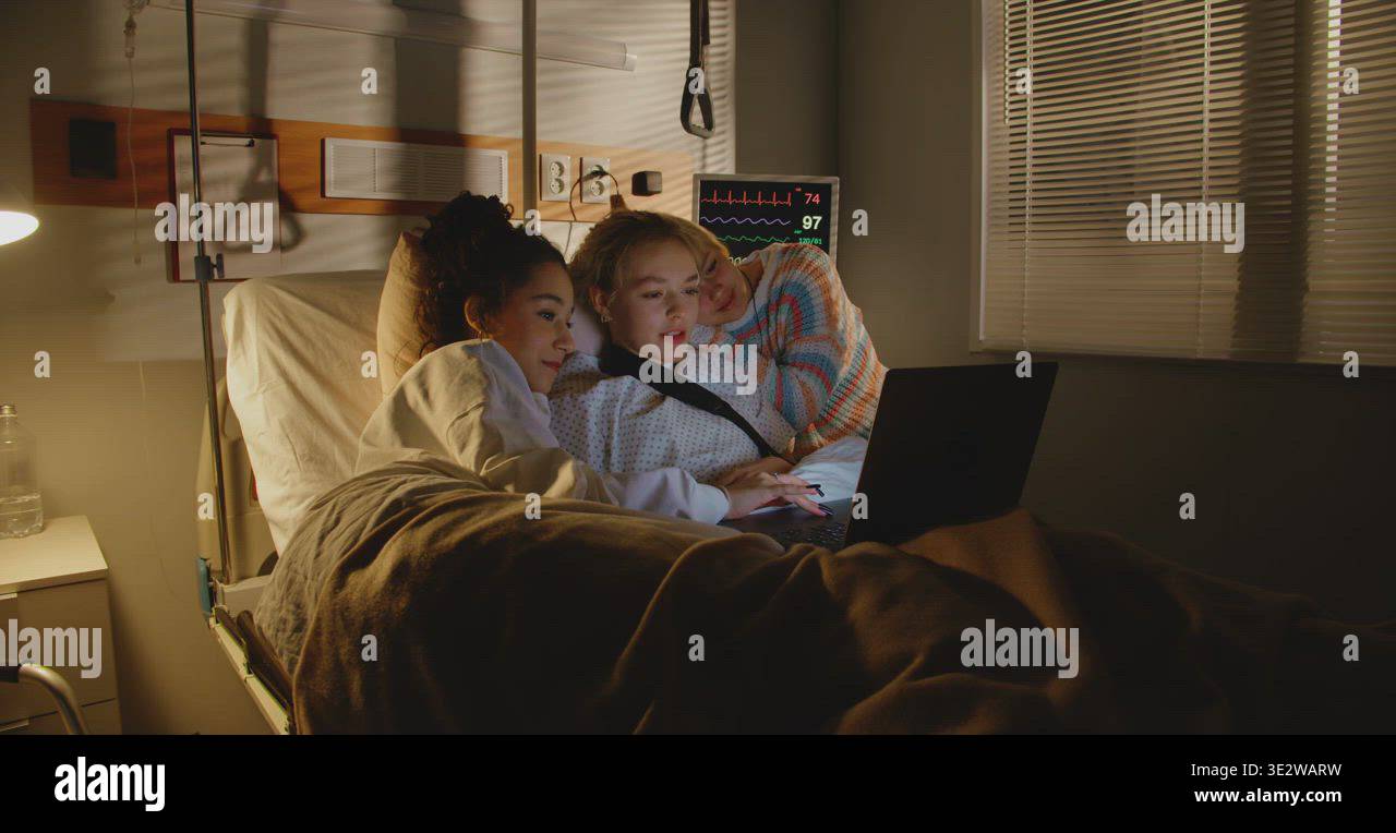 Friends visiting patient watching movie laptop Stock Video Footage - Alamy