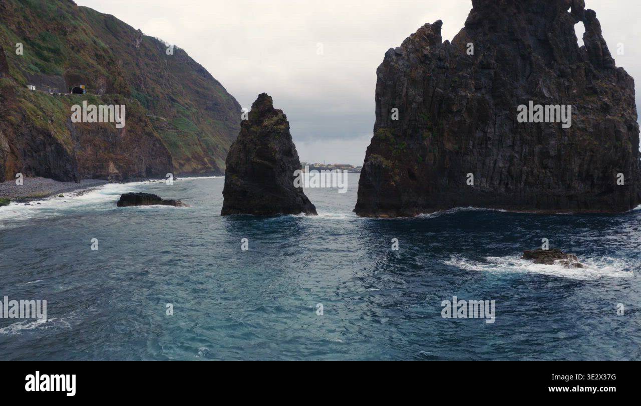 Dramatic volcanic sea stack off Madeira coast during cloudy weather ...