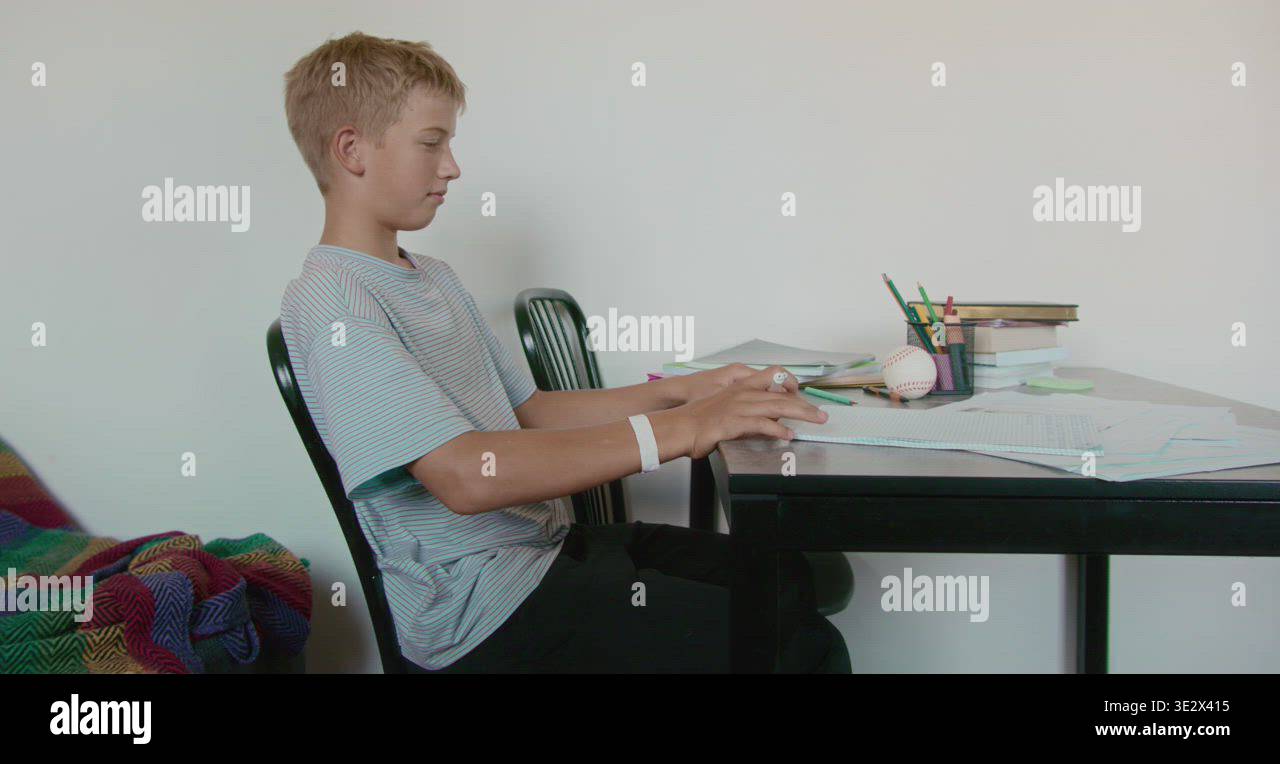 Young student performing repetitive stress injury exercises at desk ...