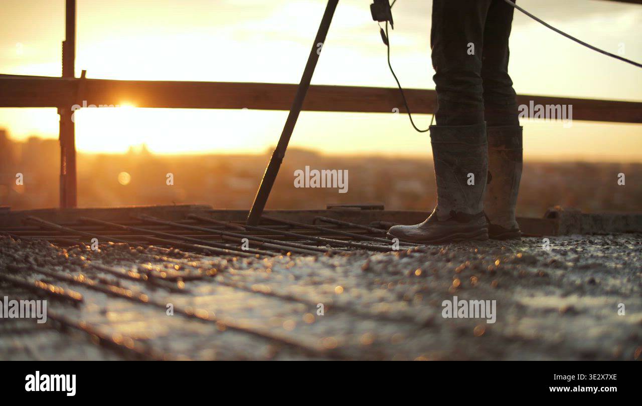 Worker vibrating concrete on reinforced slab at sunset Stock Video ...