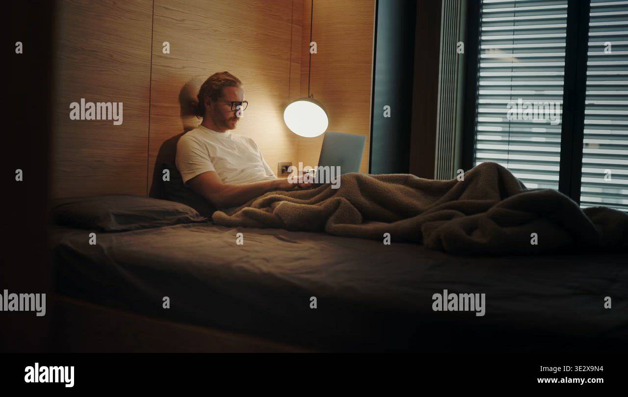 Man winding down for sleep in a cozy bedroom Stock Video Footage - Alamy
