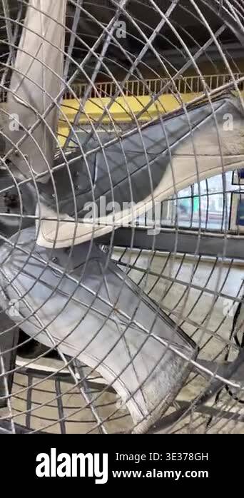 Industrial fan features metal blades and a protective grid, located in ...