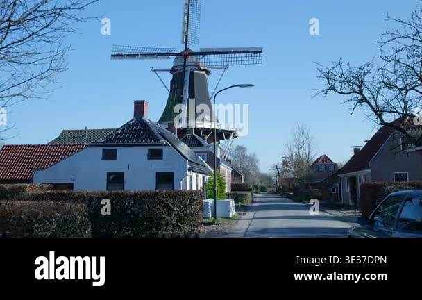 Classic dutch windmill with rotating sails in a typical small town ...
