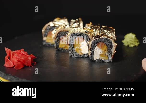 Delicious golden sushi rolls with black rice, salmon, and mango ...