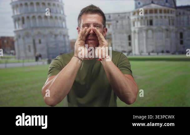 Man cupping hands to shout or call out at a building by the leaning ...