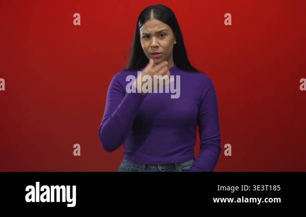 Woman wearing purple sweater pinches nose and closes eyes in studio ...