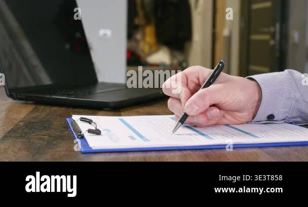 Man agent hand writes insurance claim form with pen at workplace ...
