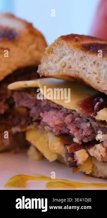 Juicy freshly cooked cheeseburger close-up, hungry man picks up the ...