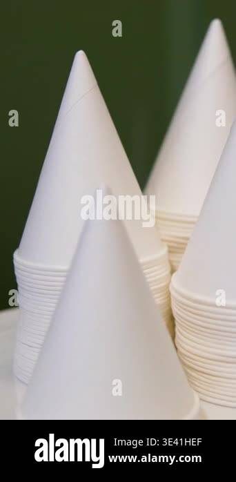 Small paper cups in triangular cone shape neatly arranged on a plate ...