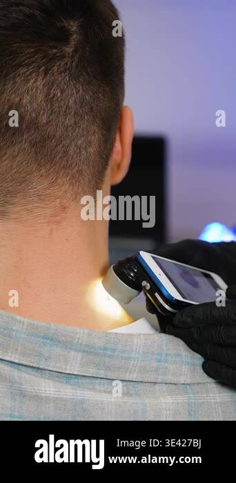 Medical professional using a modern dermatoscope attached to a ...