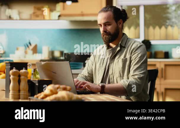 Unpunctual man, checking time on wrist watch, wooden kitchen table, guy ...
