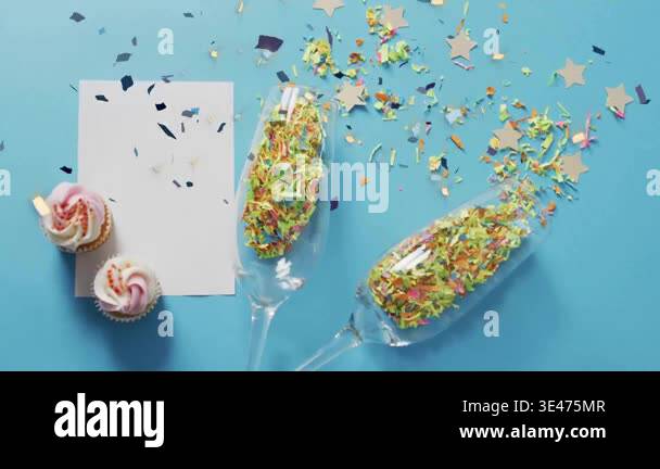 Animation of confetti over glasses, cupcakes and card with copy space ...