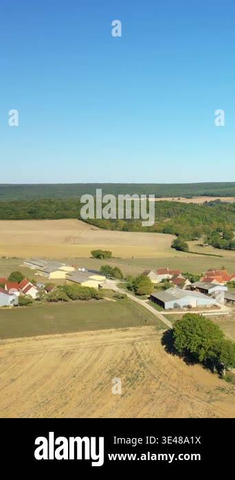 Drone shot of a peaceful rural landscape with fields, farm buildings ...