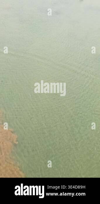 Calm, clear shallow river water with visible ripples and a hint of ...