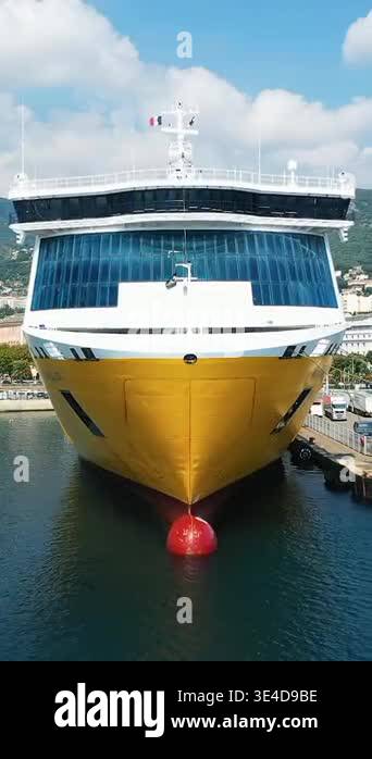 Front view of a large yellow ferry docked at the harbor in Bastia ...